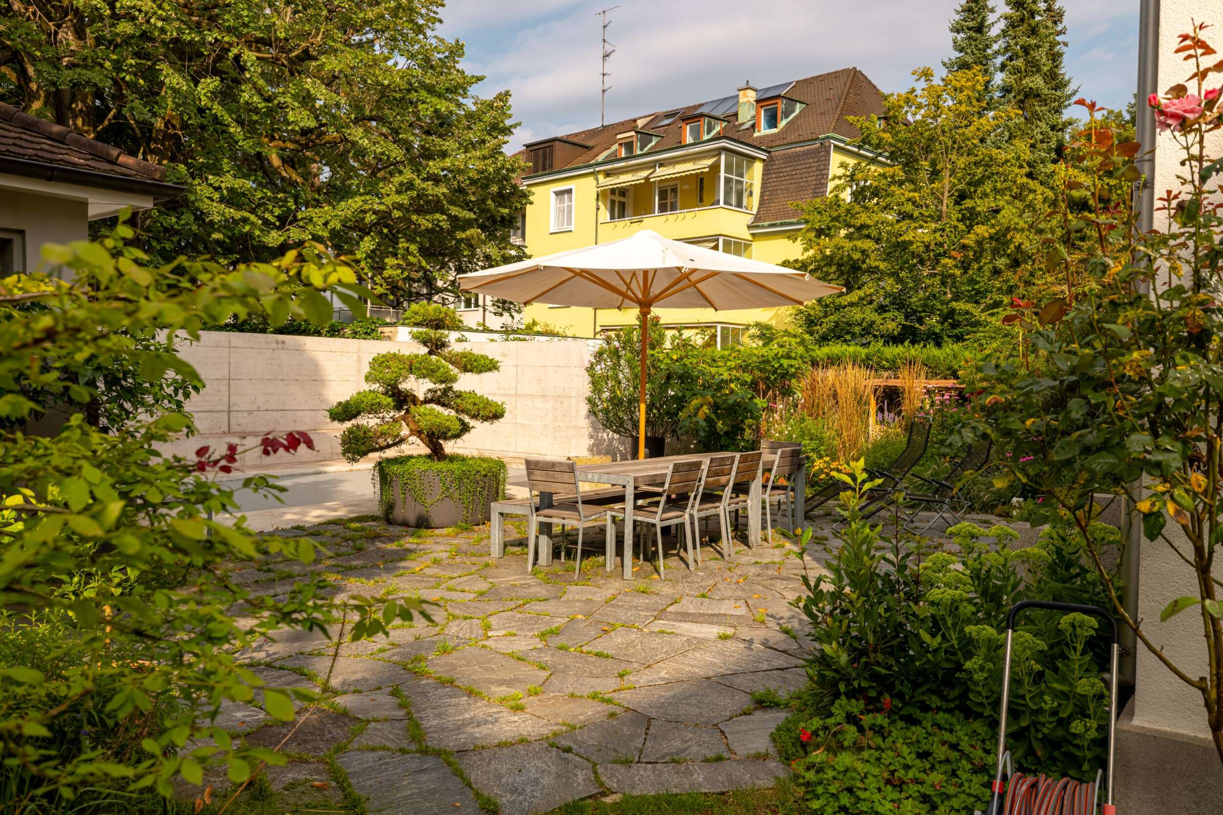 Naturstein-Sitzplatz mit begrünten Fugen – AvantGarten